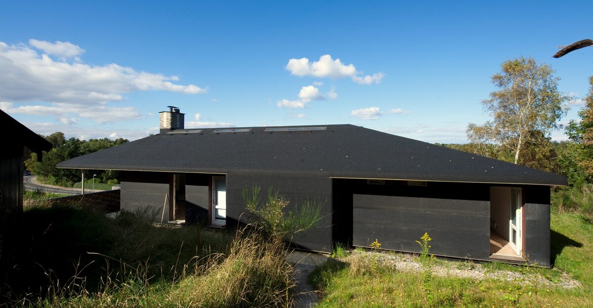 Sommerhus pakket ind i sort tagpap